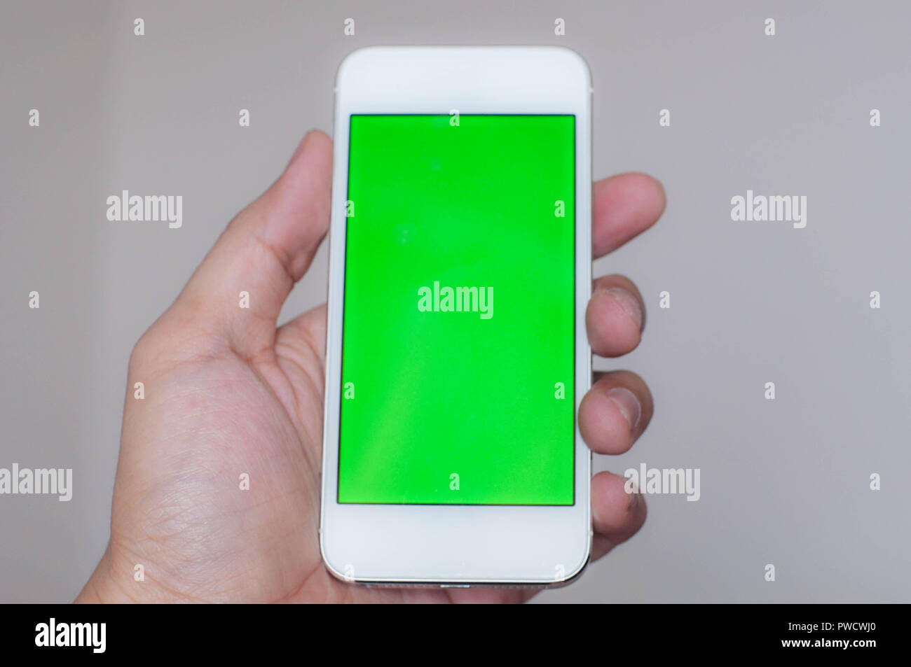 Young man holding a smart phone with green screen Stock Photo - Alamy