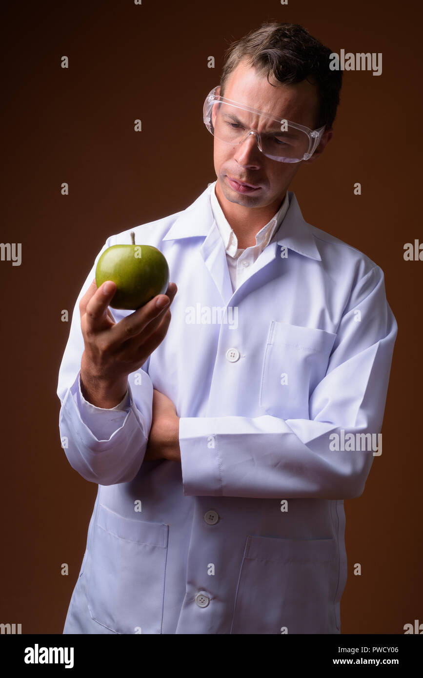 Studio shot of man doctor against brown background Stock Photo - Alamy