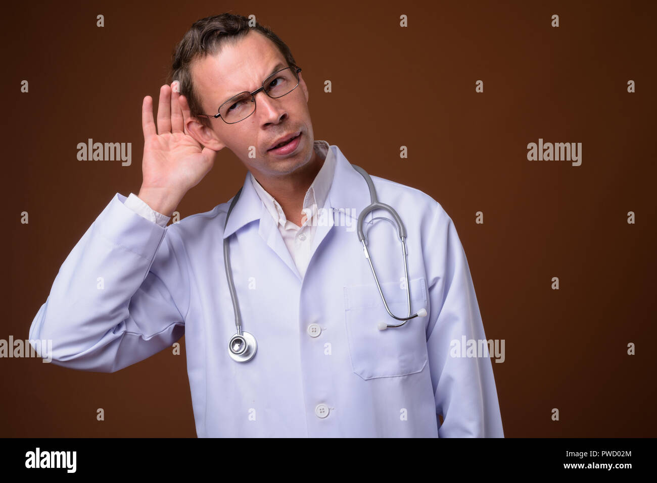 Studio shot of man doctor against brown background Stock Photo - Alamy