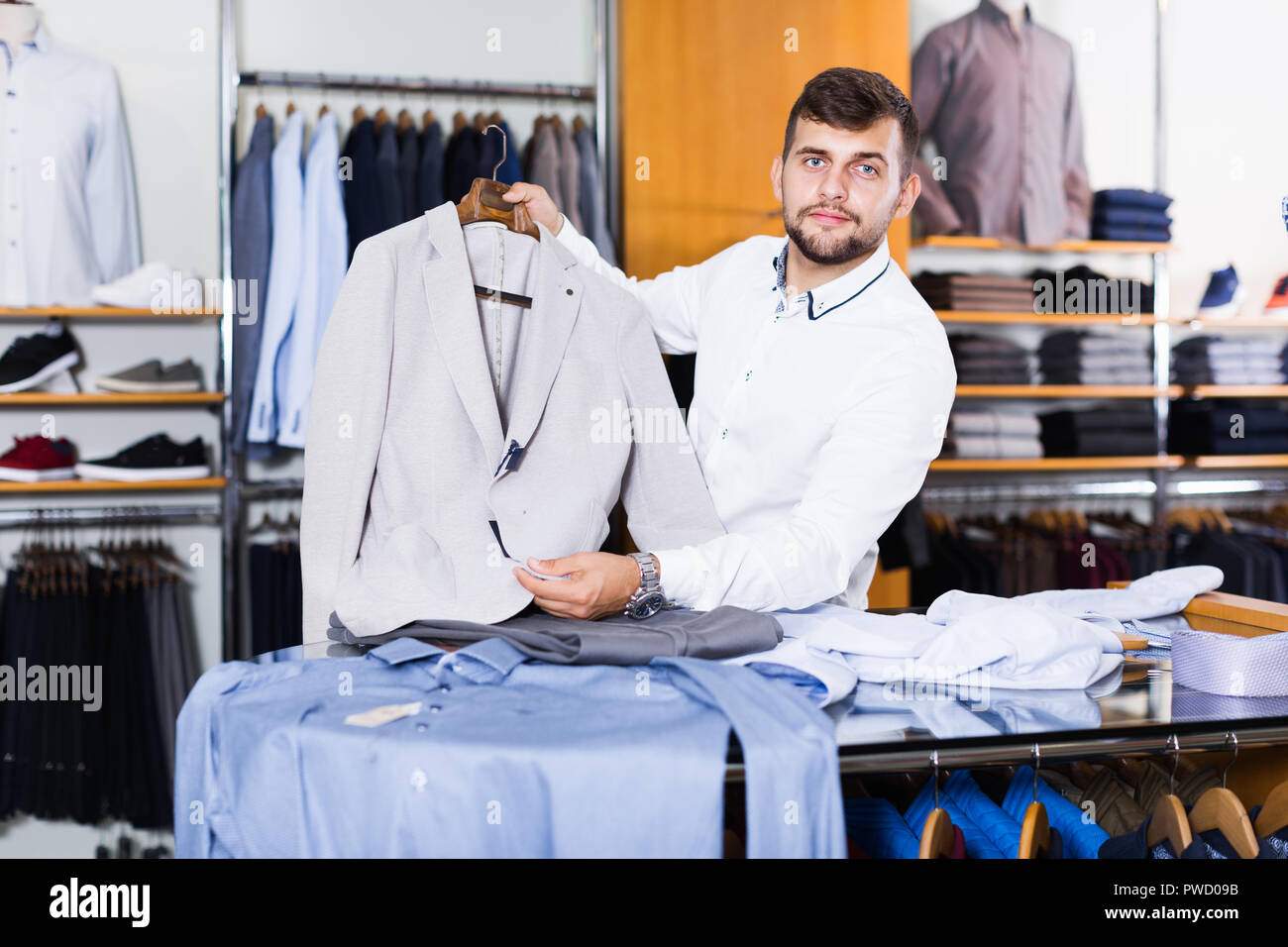 Adult man customer choosing jacket in men clothes shop Stock Photo - Alamy
