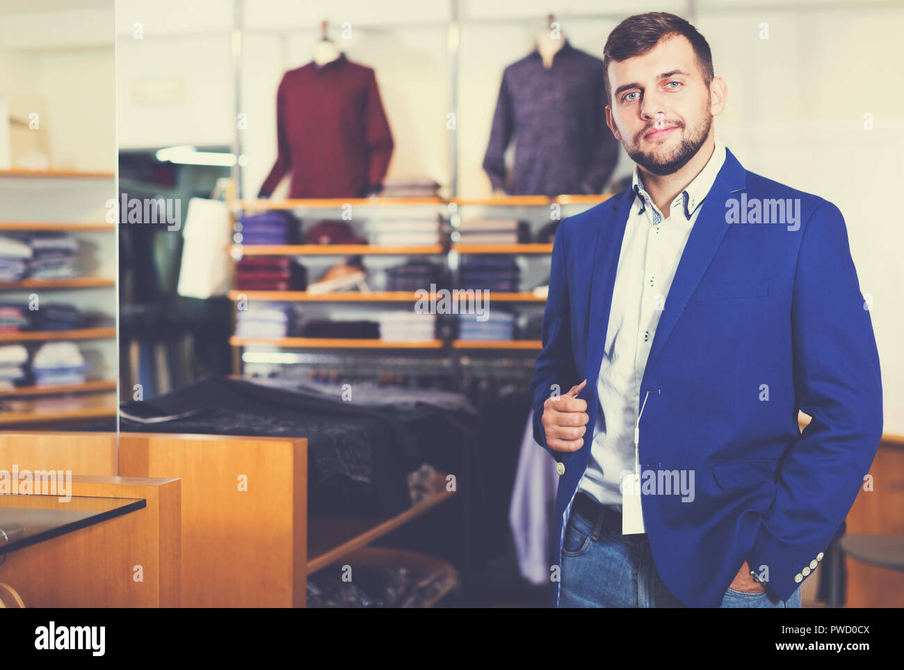 happy french man choosing casual jacket in fashion store Stock Photo ...