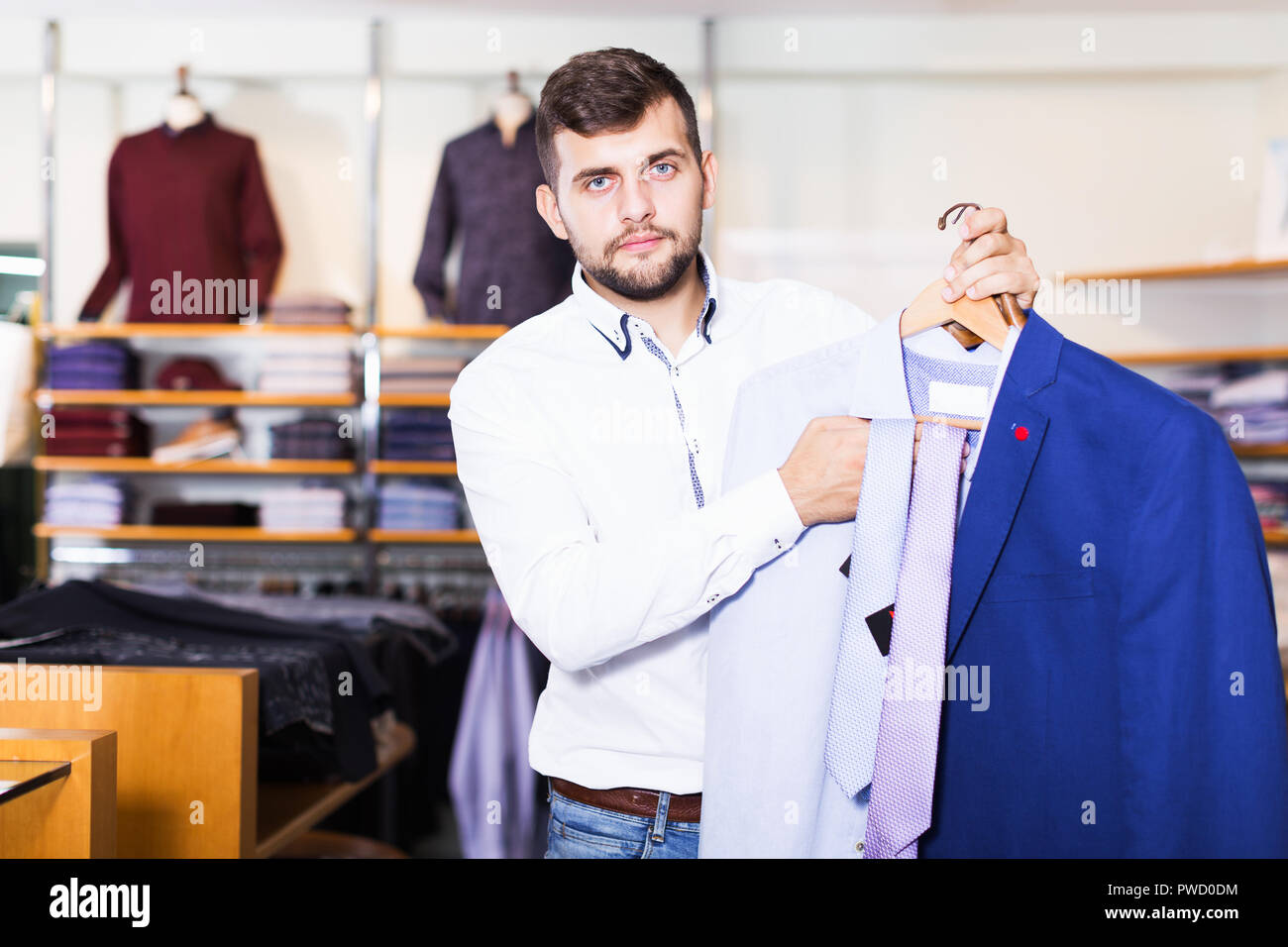positive adult owner guy displaying jacket in fashion store Stock Photo ...