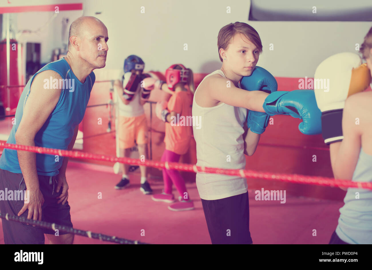 Teenagers at boxing training with instructor on boxing ring Stock Photo ...