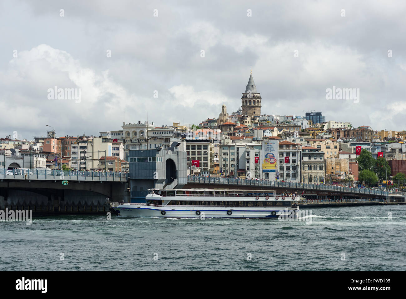 A large passenger ferry sailing towards Galata bridge with Galata ...