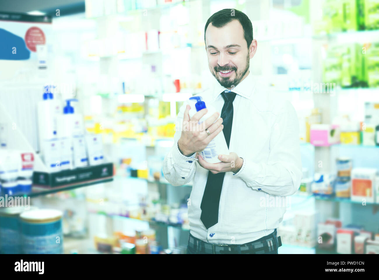 Smiling male customer searching for reliable drug in pharmacy Stock ...