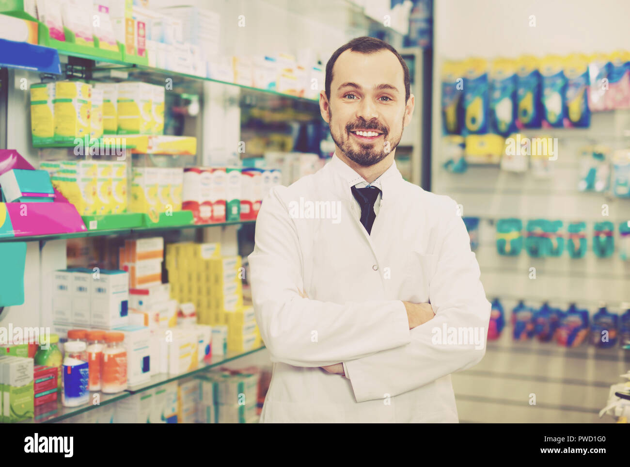 Happy positive male pharmacist demonstrating assortment of drugs in ...