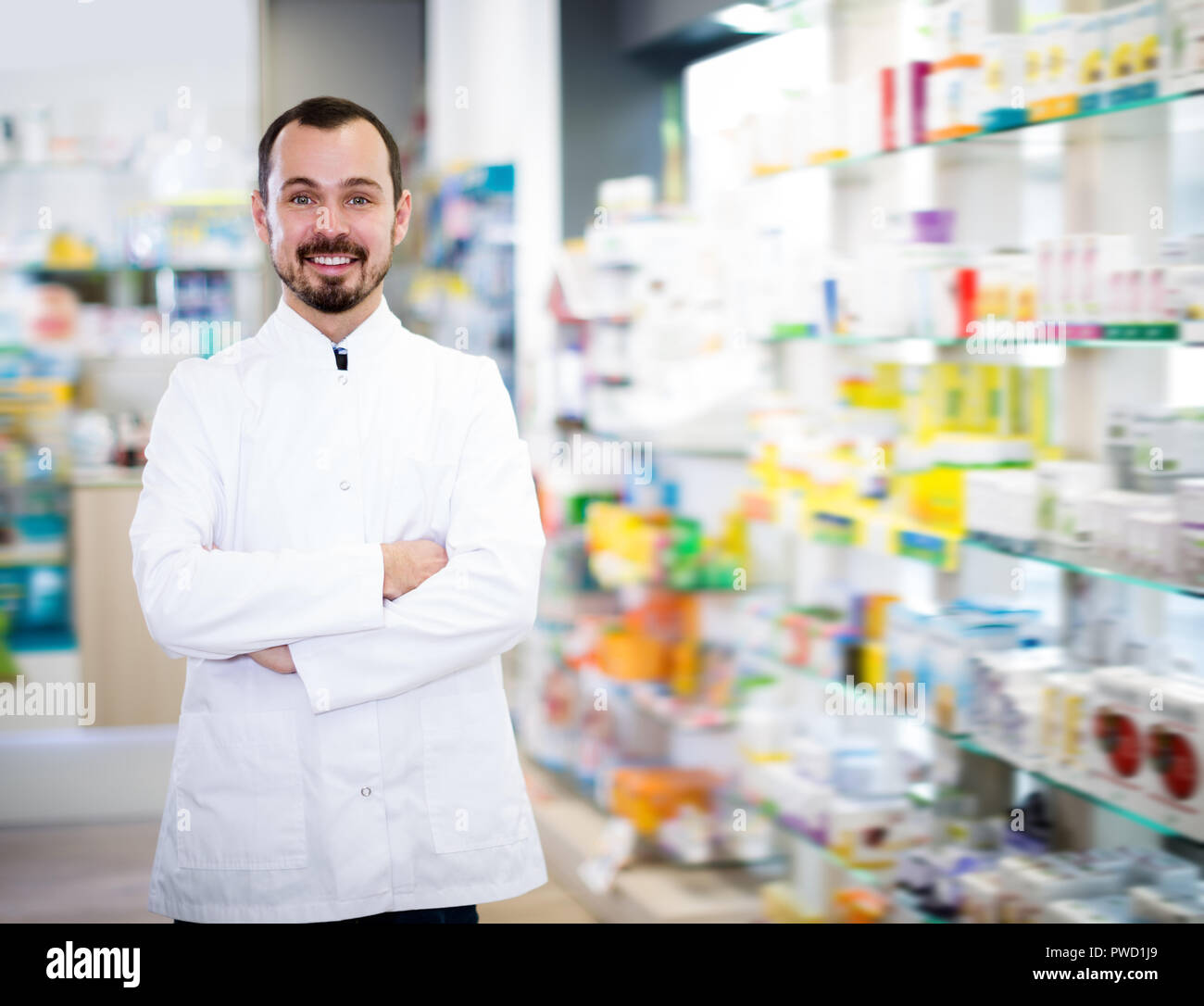Young pharmacist showing assortment of drugs in pharmacy Stock Photo ...