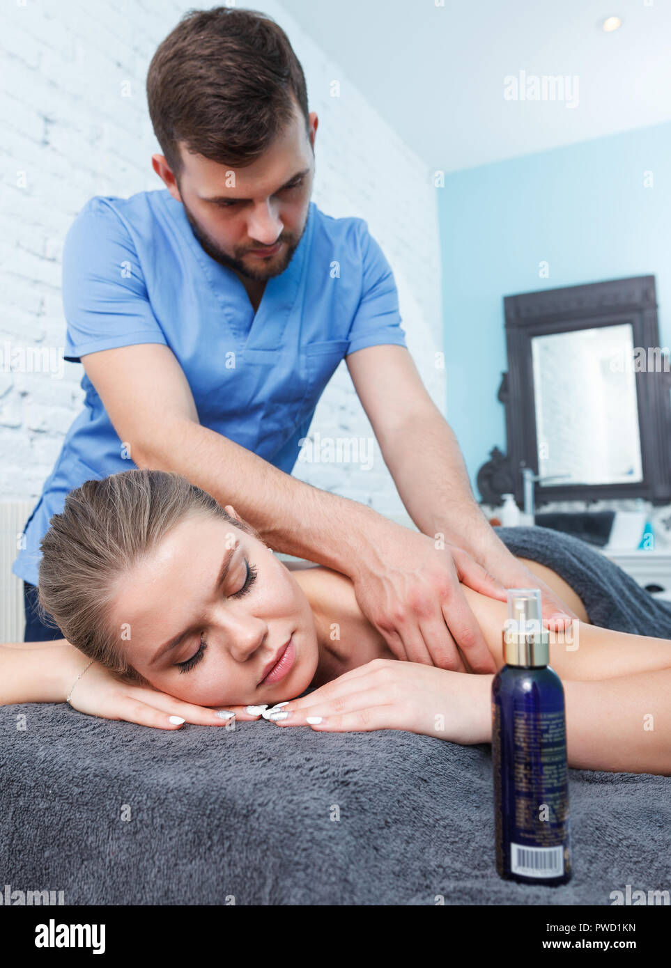 Portrait of glad woman enjoying relaxing massage by professional ...