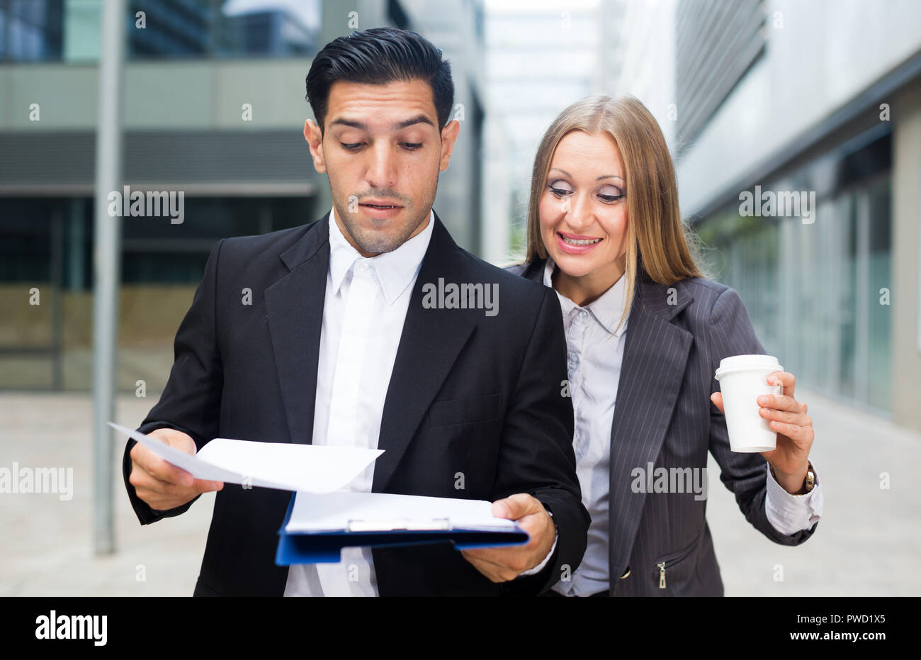 Businesswoman with her employee are drinking coffee and reading ...