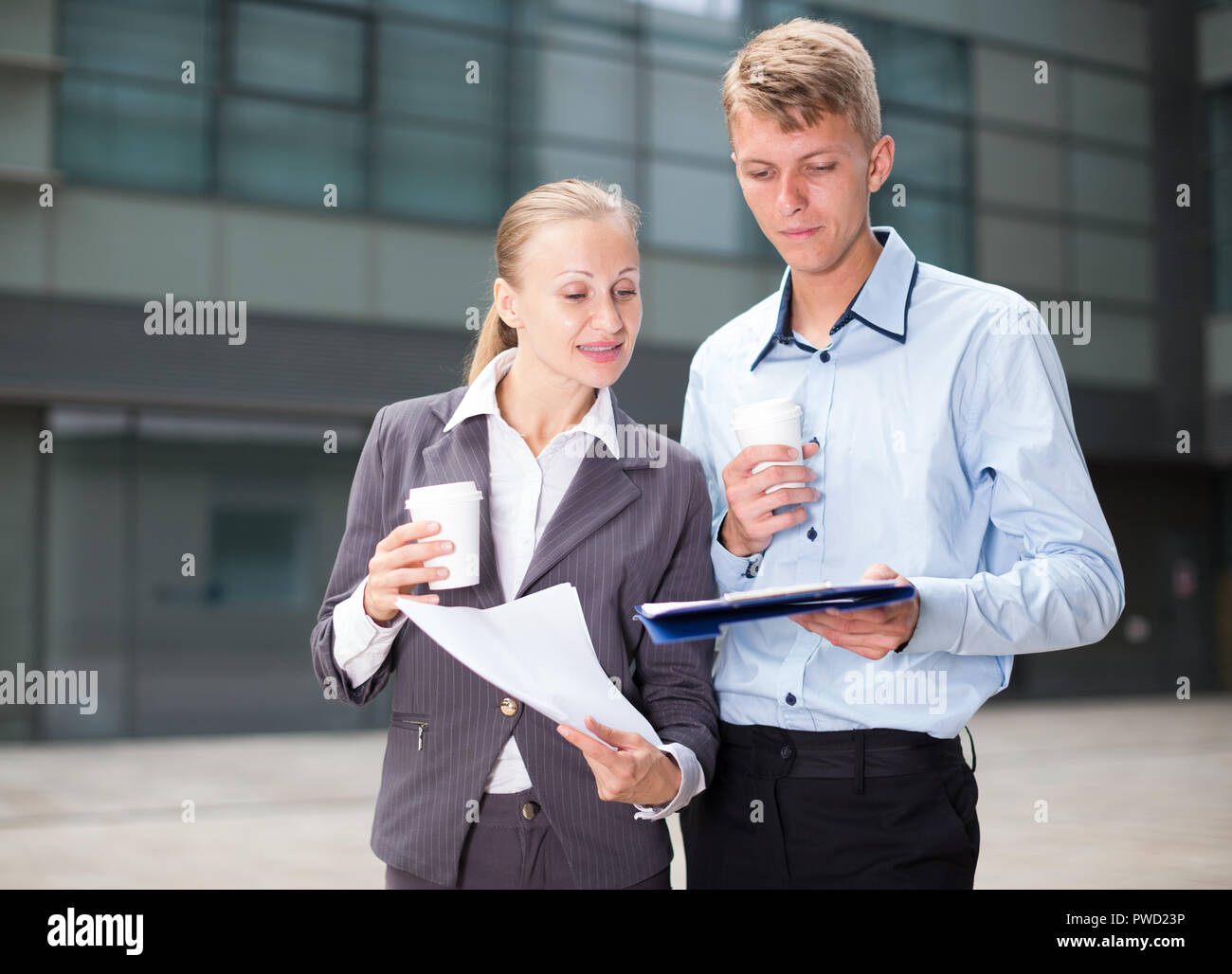 Young businessman and his colleague are reading documents before ...