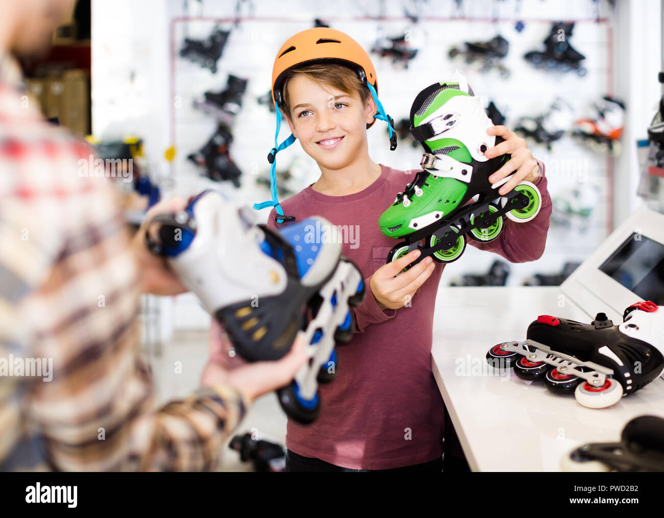 happy male shop assistant helping positive american boy to choose ...
