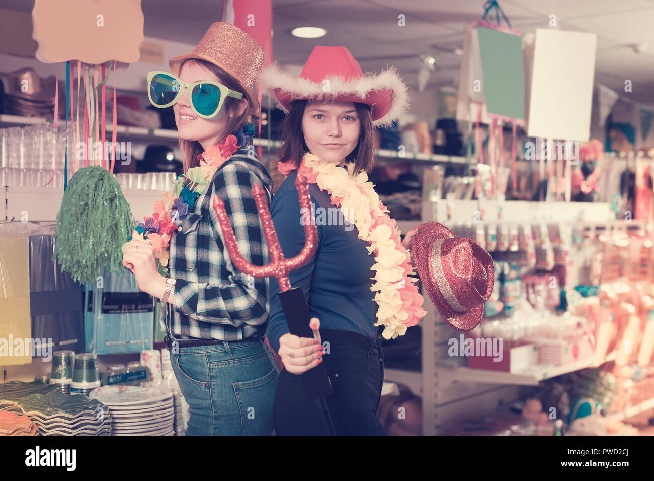 friendly girls shopping together, looking for funny things in store of ...
