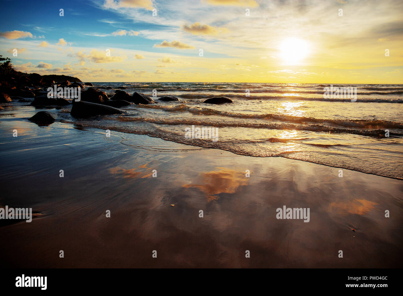 Sand beach at sea with the sunset Stock Photo - Alamy