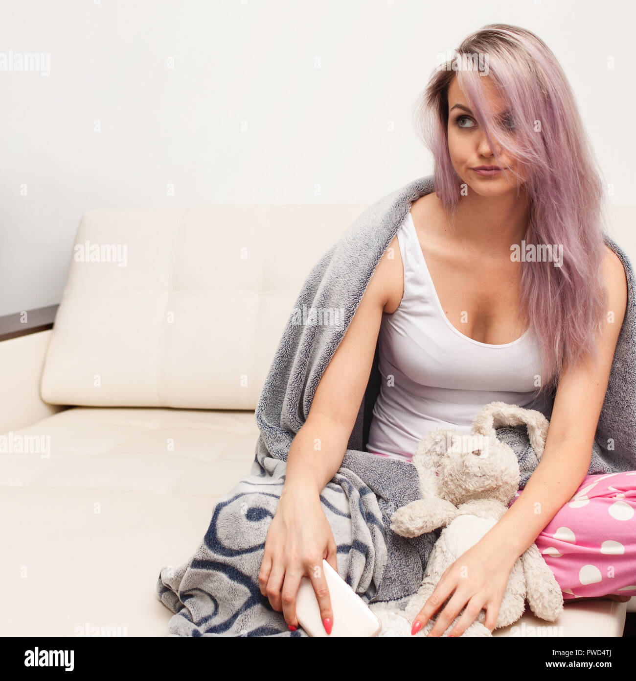 Not invited to the party. Young attractive woman alone is sad at home ...