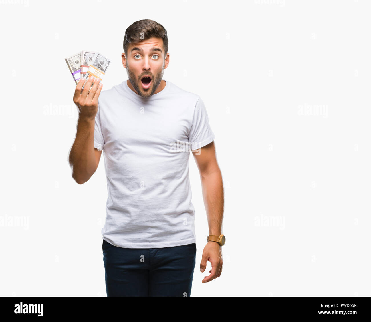 Young handsome man holding stack of dollars over isolated background ...