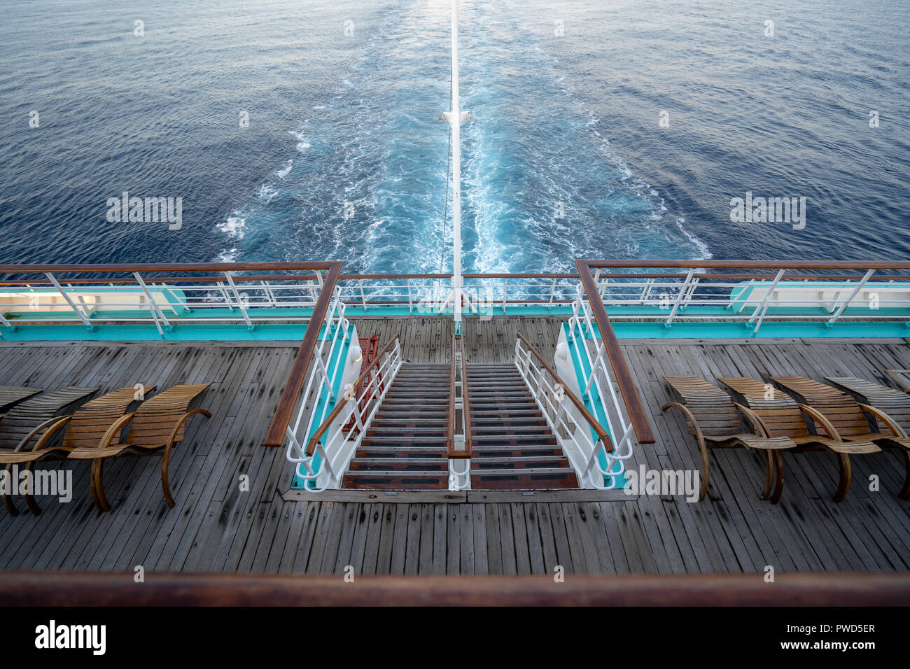 Rear part of the ship with waves in the Ocean and some deck chairs an ...