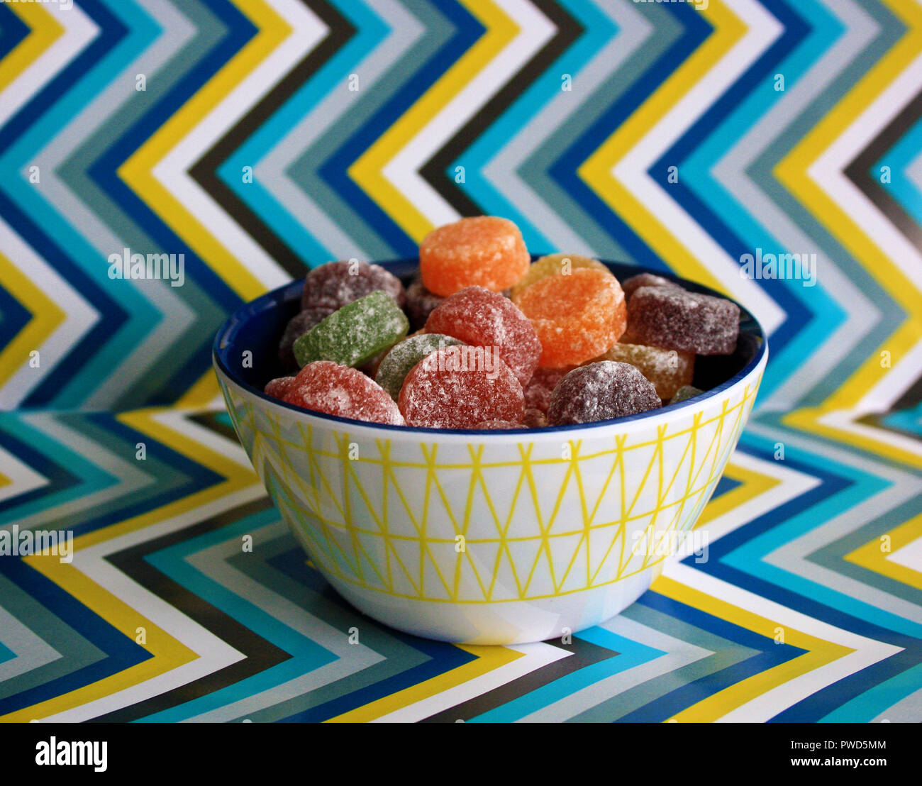 A colourful bowl of sweets/candy with a zigzag background Stock Photo ...
