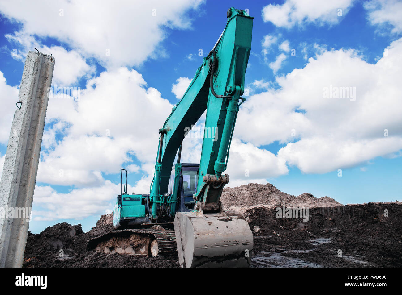 Excavator in construction with blue sky background Stock Photo - Alamy