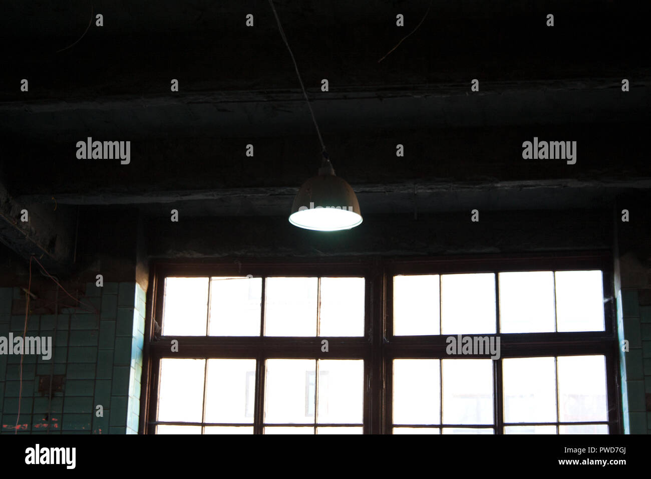Industrial interior: lamp under the ceiling and upper part of window ...
