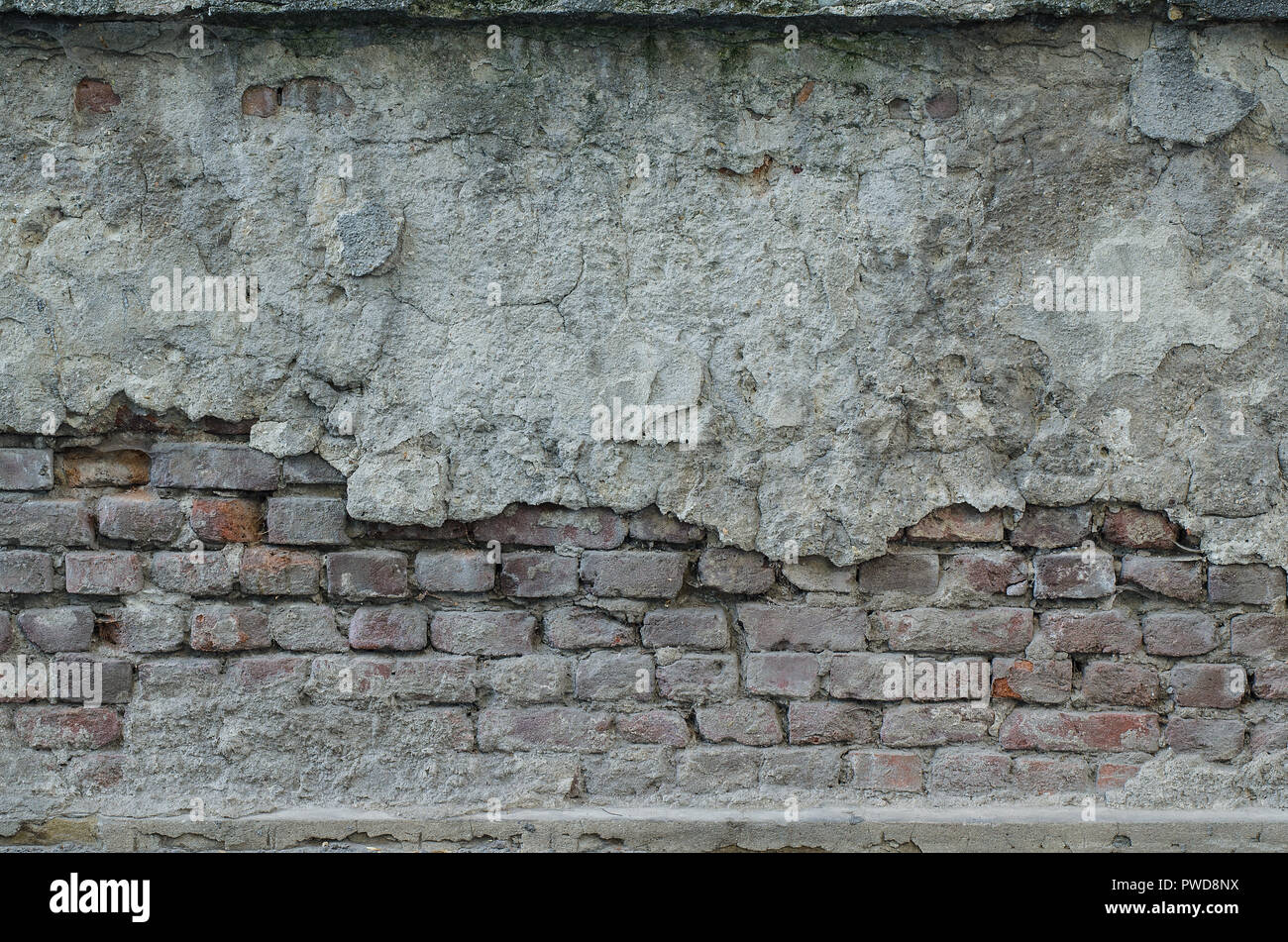 Old a masonry with red slightly broken bricks. Plaster are partly ...