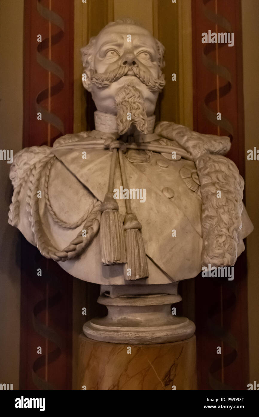 A man with a great moustache and goatee is carved as a bust on a plinth ...
