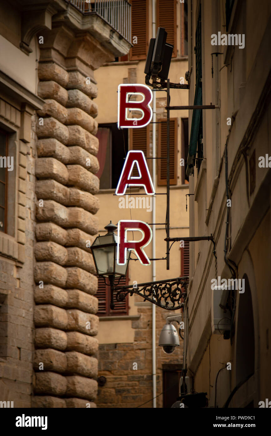 A vintage neon bar sign juts out from the side of a building in ...