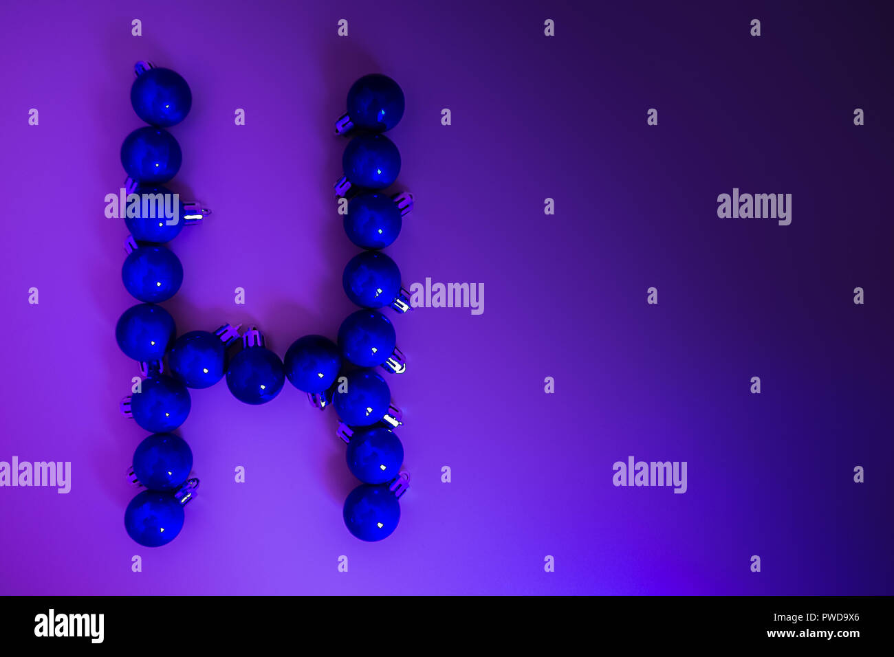 Christmas alphabet of blue neon Christmas balls on a gradient lilac ...