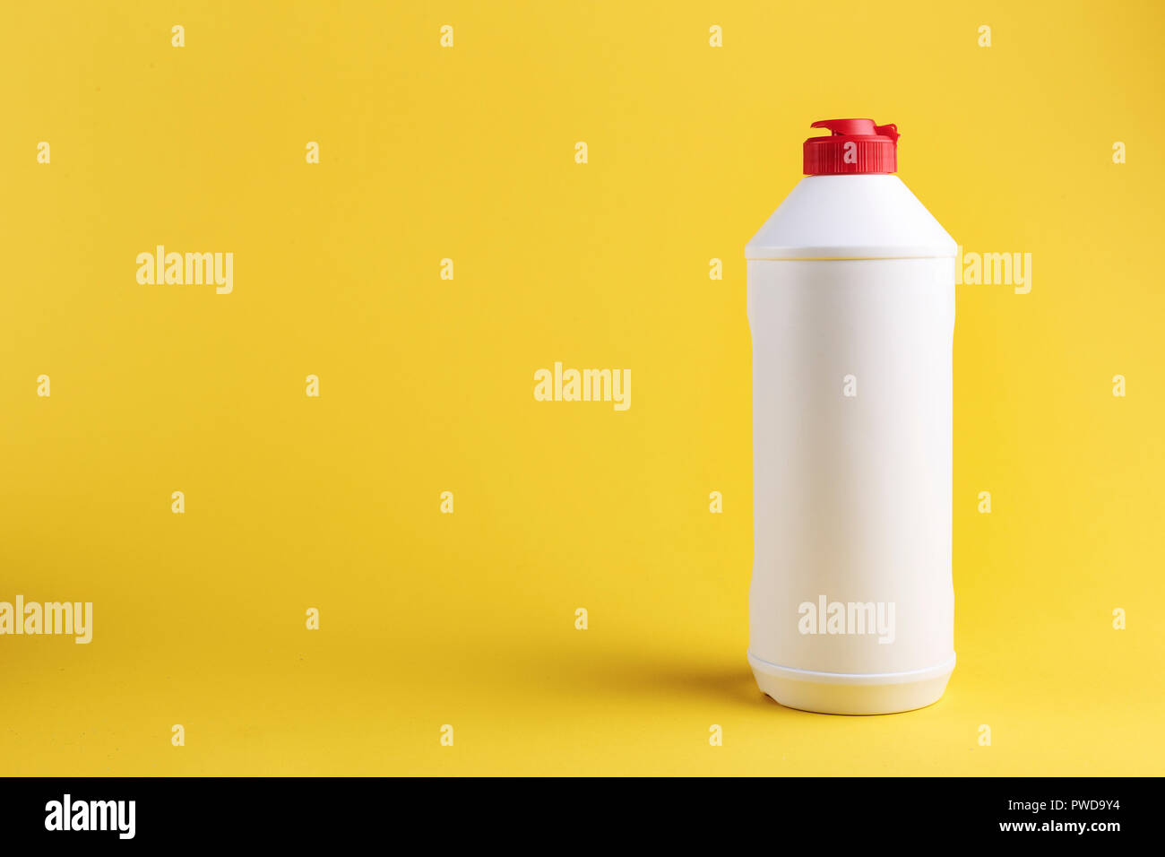white plastic bottle with detergent without label on a yellow ...
