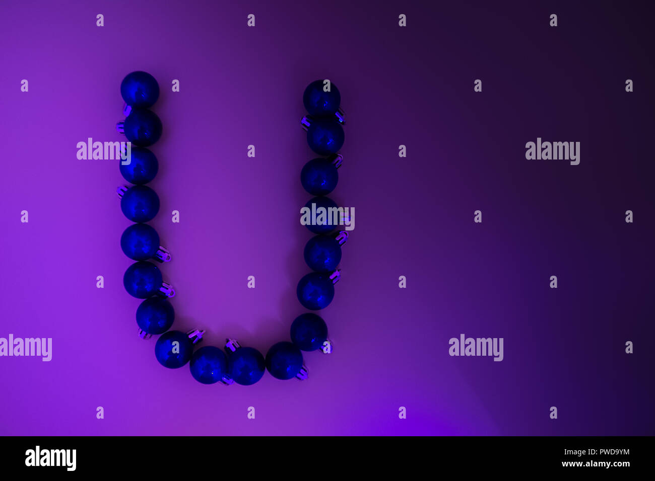 Christmas alphabet of blue neon Christmas balls on a gradient lilac ...