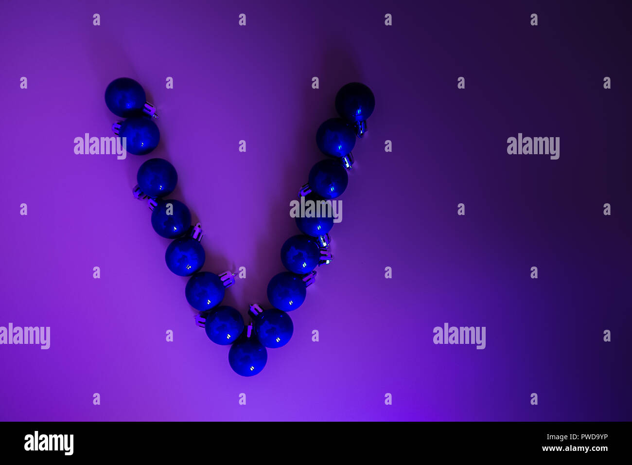 Christmas alphabet of blue neon Christmas balls on a gradient lilac ...