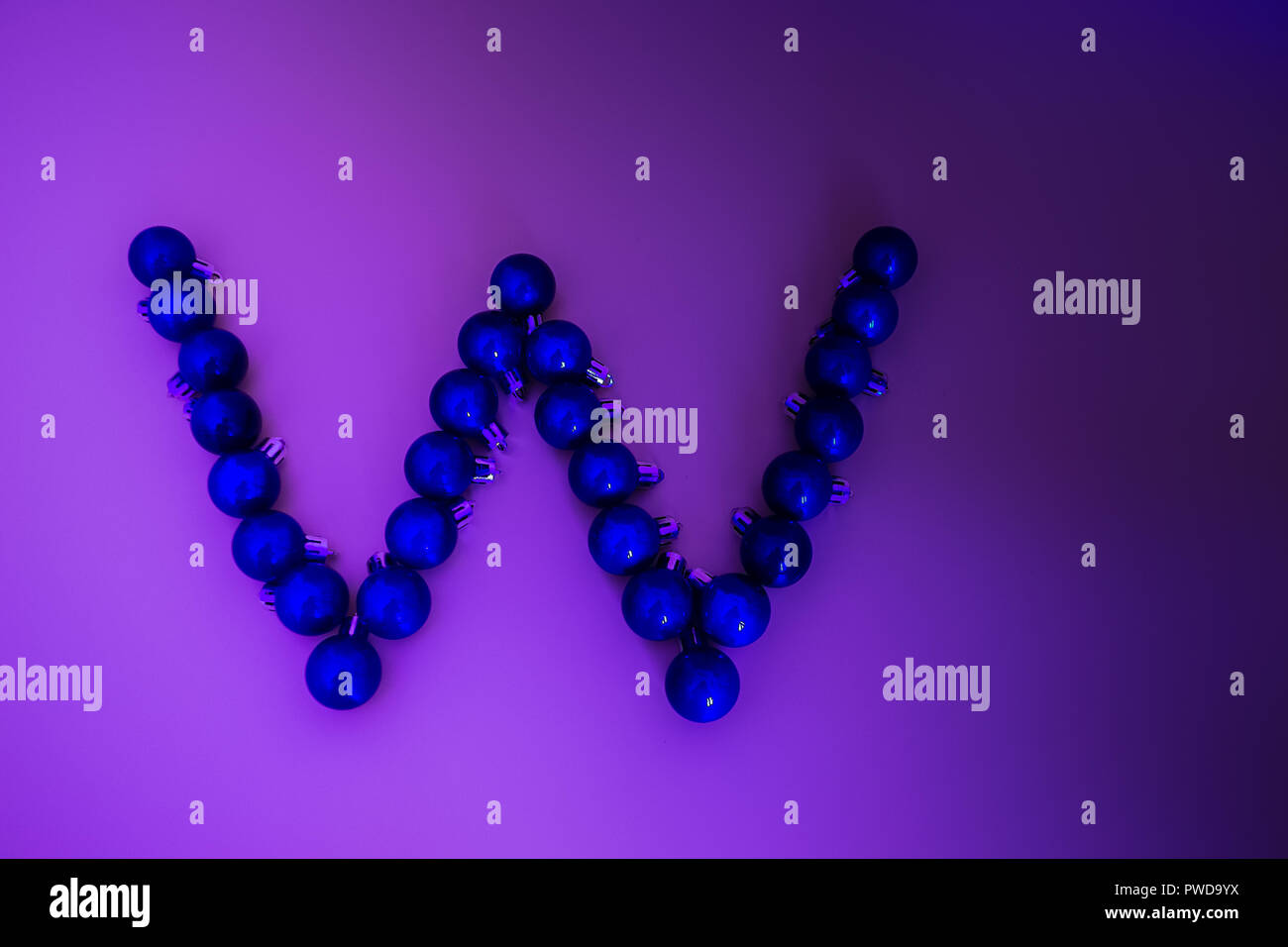 Christmas alphabet of blue neon Christmas balls on a gradient lilac ...