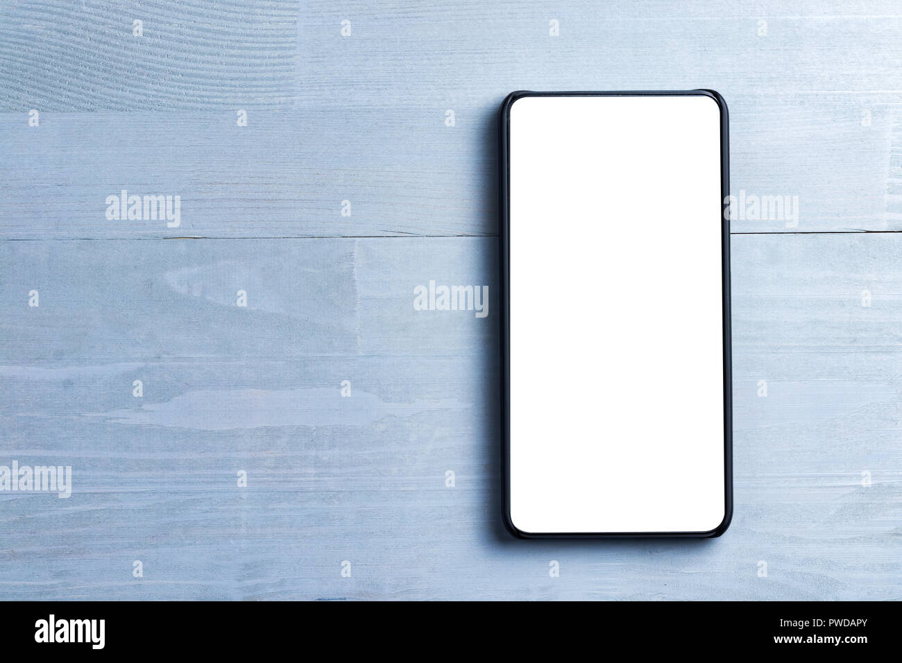 Bezel less smart phone with blank screen on a wooden background. Copy ...