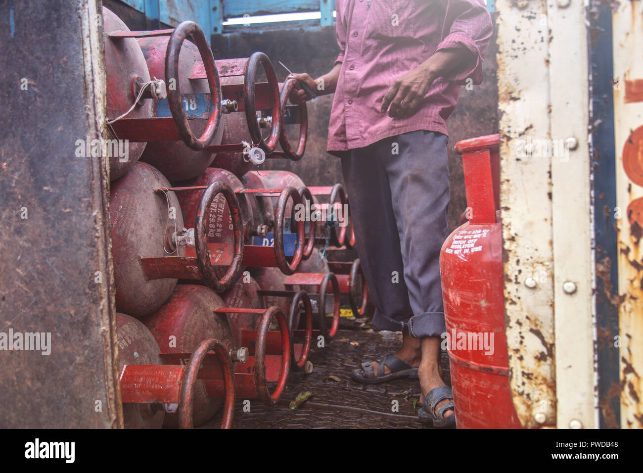 Worker delivering LPG gas cylinders into the truck for customers Stock ...
