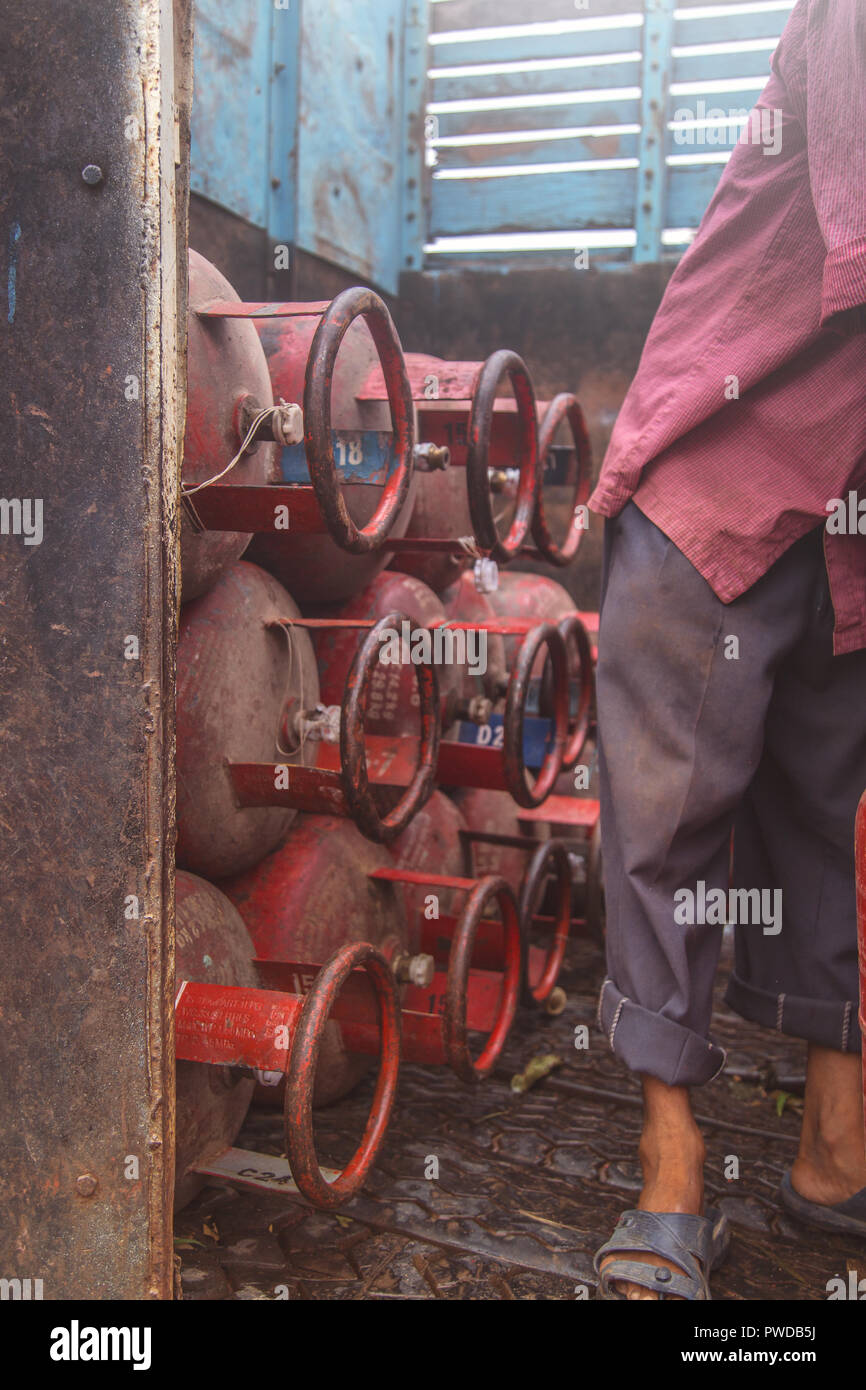 Worker delivering LPG gas cylinders into the truck for customers Stock ...