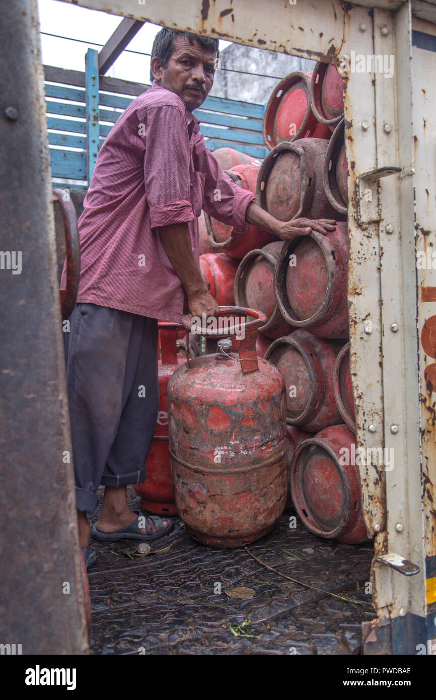 Worker delivering LPG gas cylinders into the truck for customers Stock ...