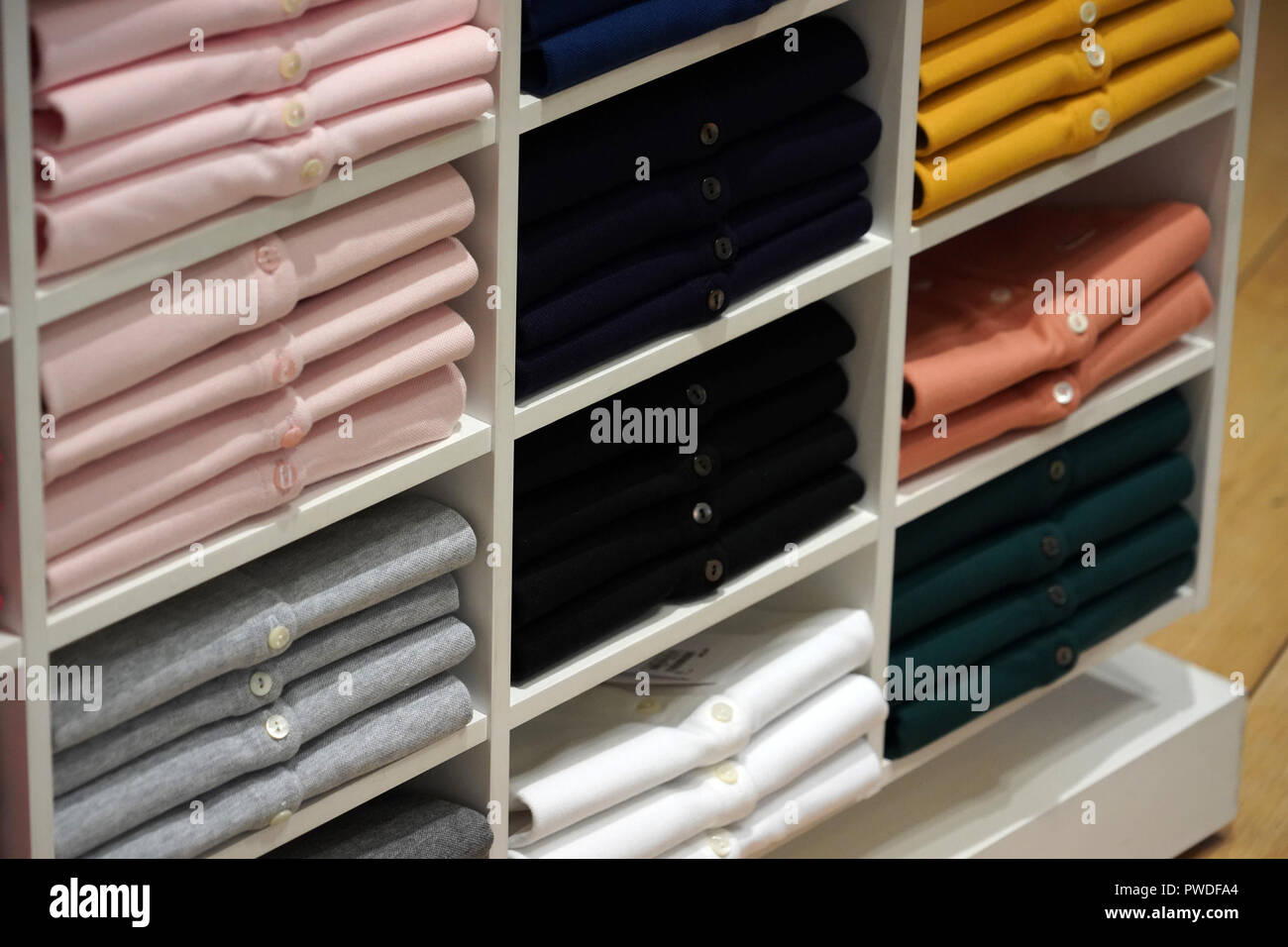 different colors polo shirt on display stand Stock Photo - Alamy