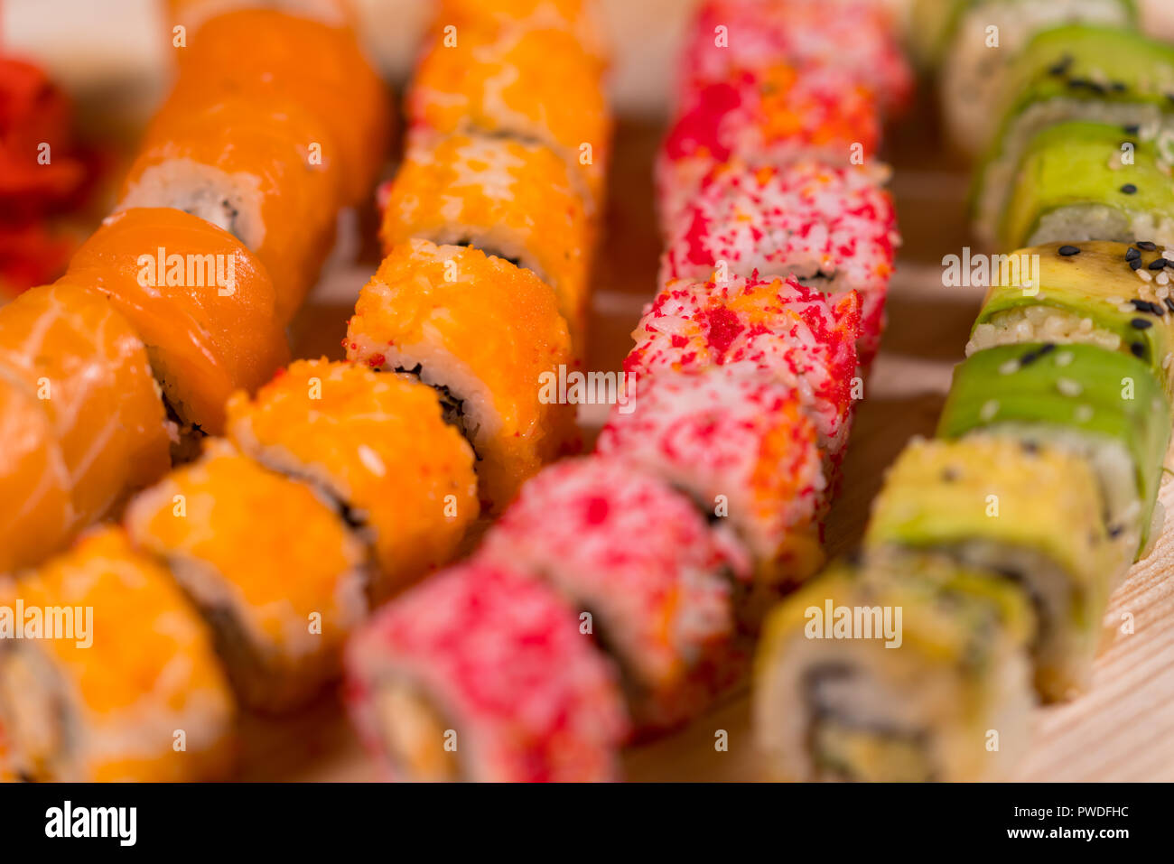 Colorful assortment of sushi rolls on a circular board on a buffet ...