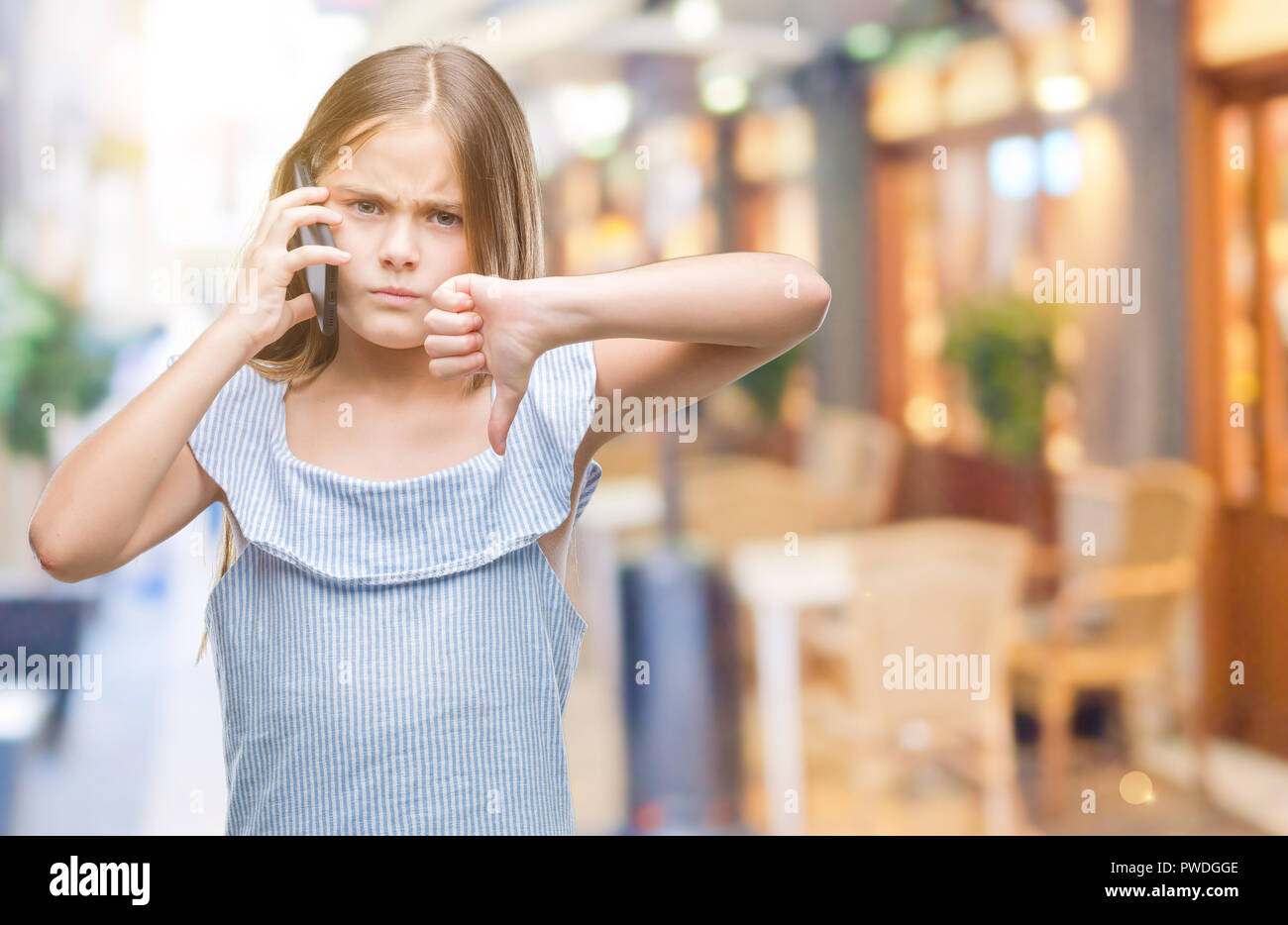 Young beautiful girl talking on the phone over isolated background with ...