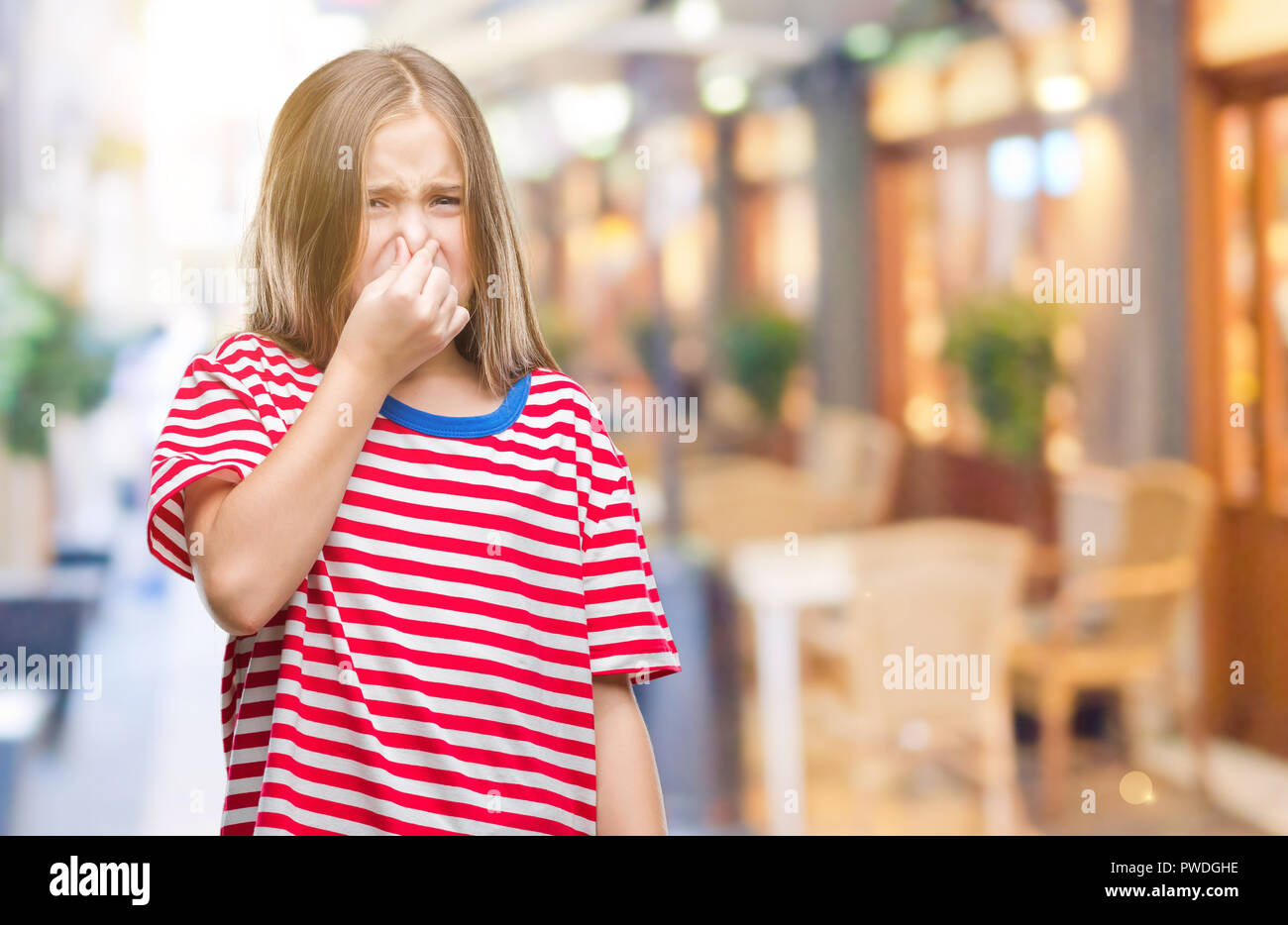 Young beautiful girl over isolated background smelling something stinky ...