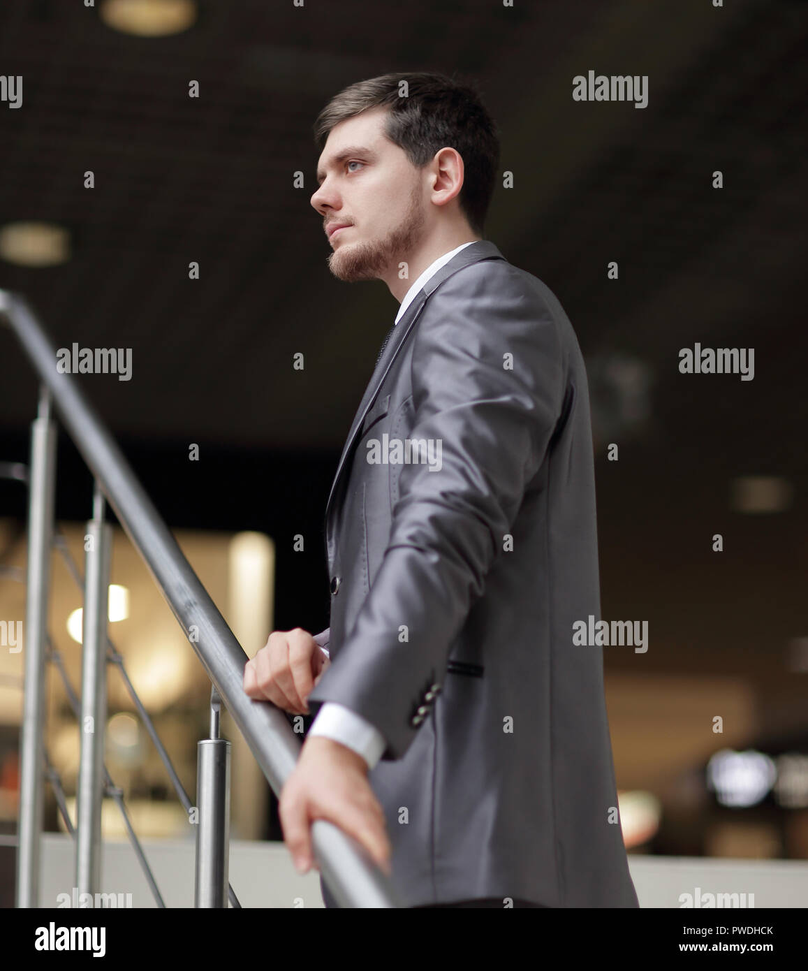 successful businessman standing on stairs in office building Stock ...