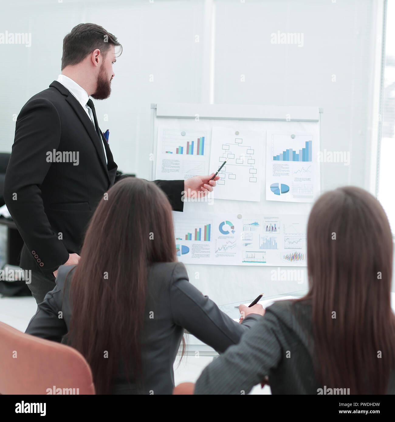 business coach teaching employees on whiteboard at corporate training ...