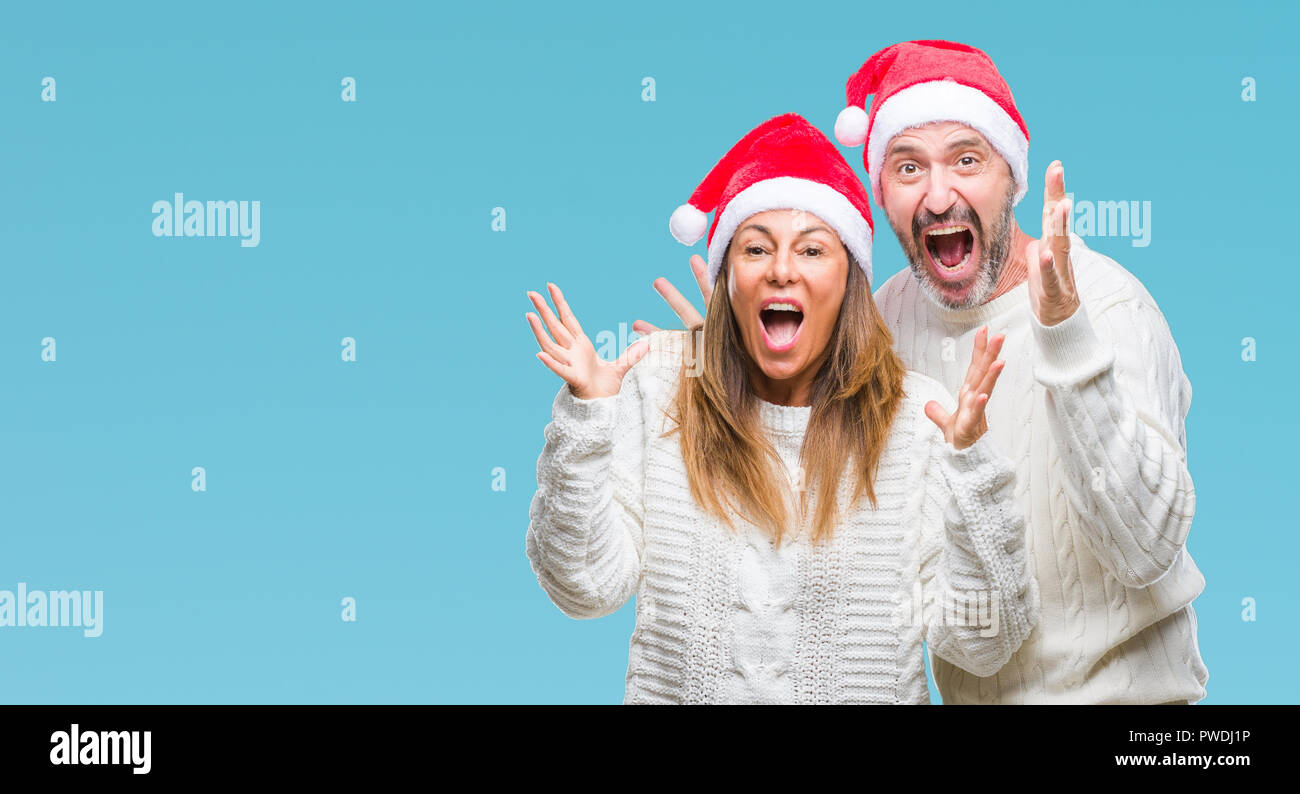 Middle age hispanic couple wearing christmas hat over isolated ...