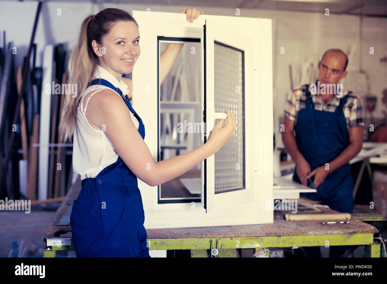 Adult girl in workwear with finished window from pvc profile at ...