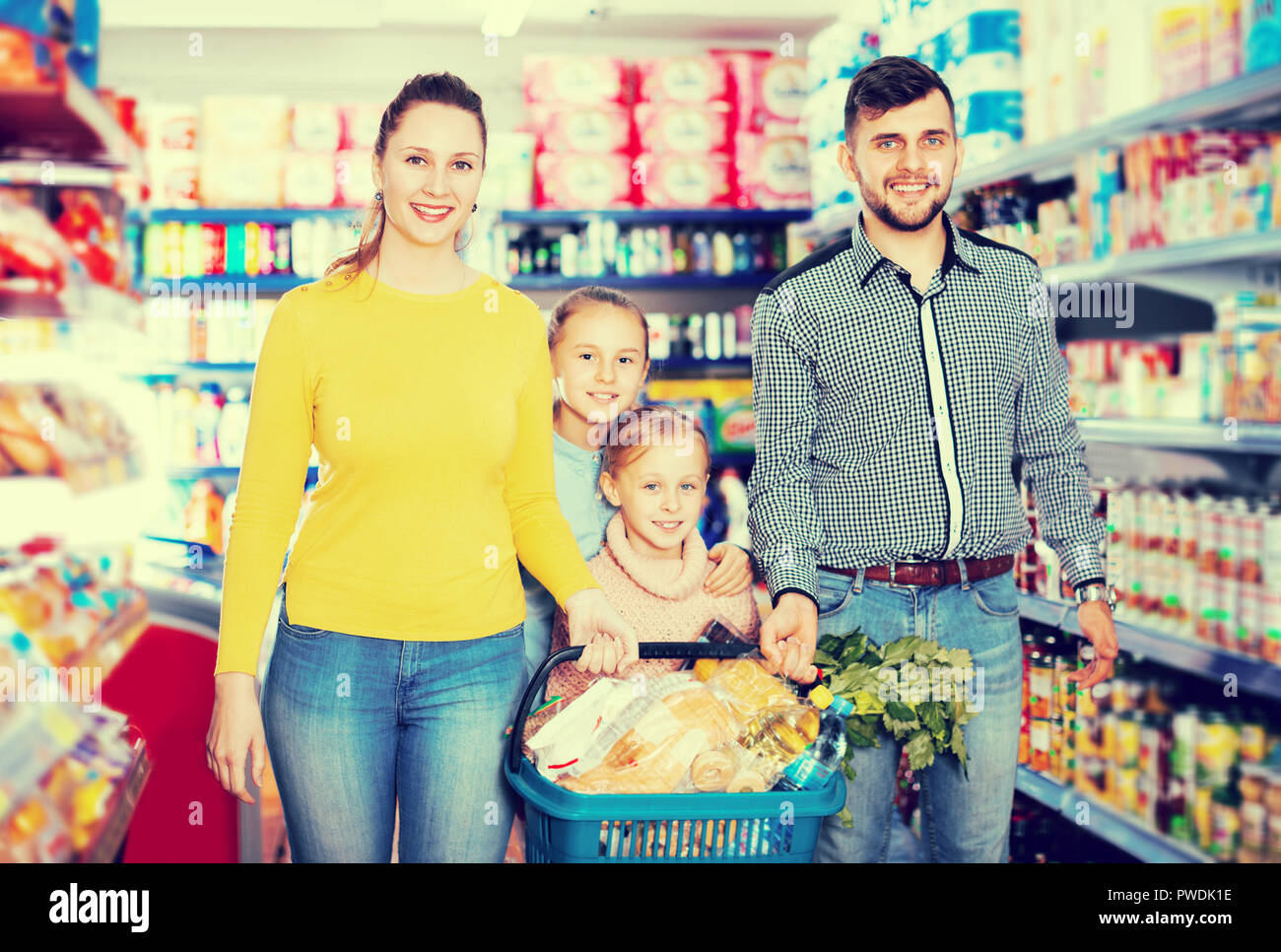 Happy parents with two little girls with purchases during family ...