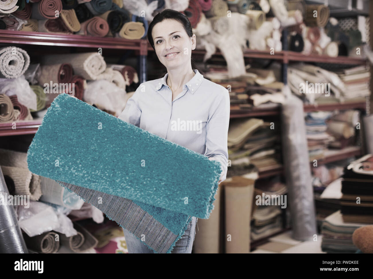 Female touching and choosing carpets in the store before the buying ...