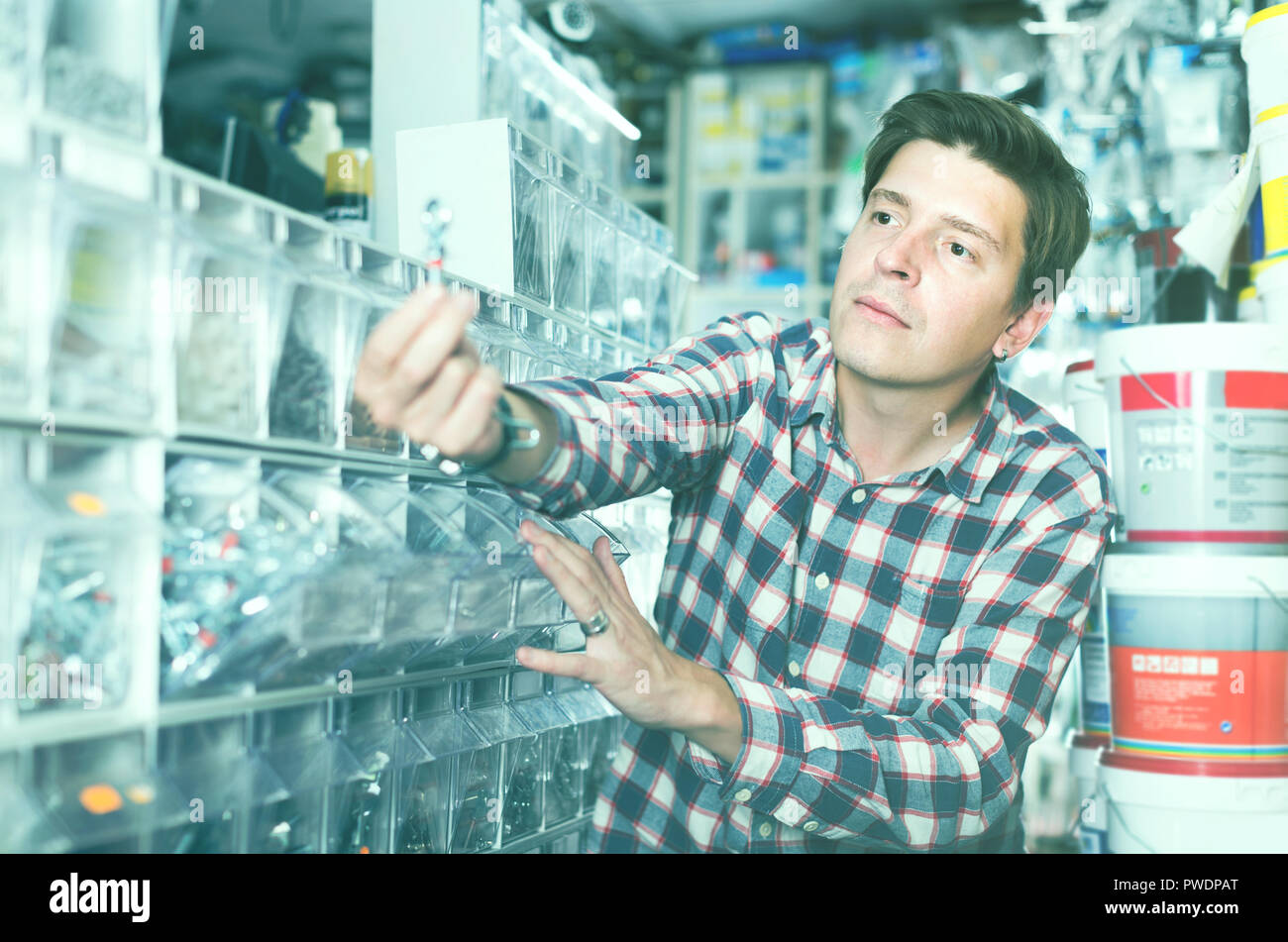 Positive male customer in hardware shop buying goods for repair Stock ...