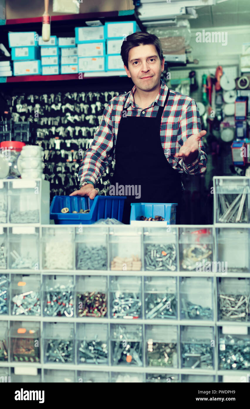 Cheerful italian worker in hardware store trading goods for water tap ...