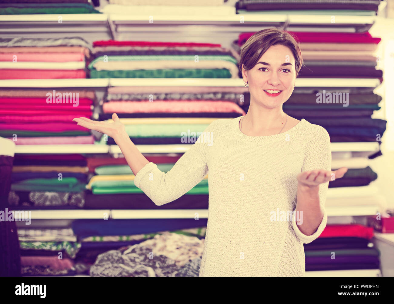 Female shop assistant demonstrating assortment at drapery shop Stock ...