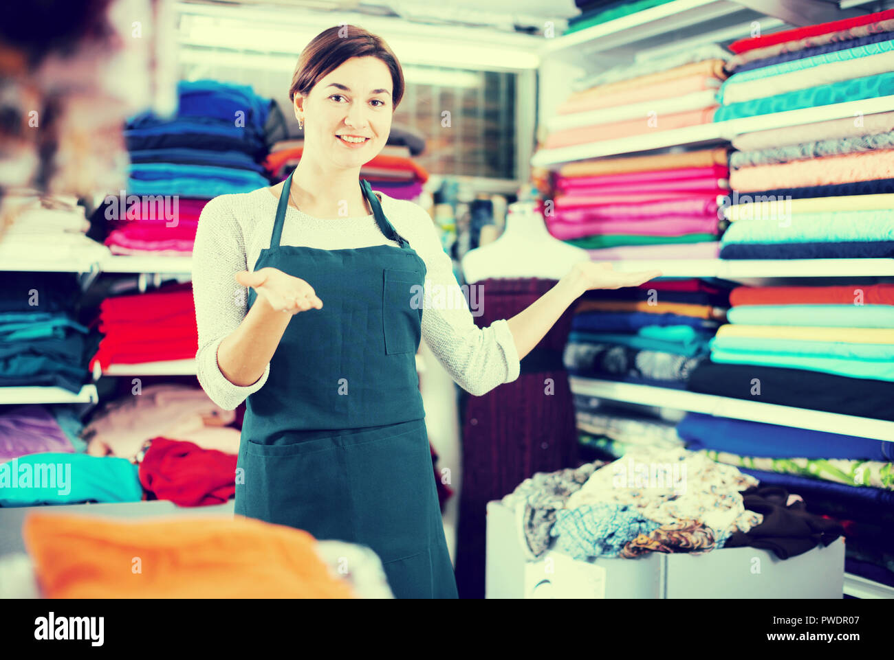 Female shop assistant demonstrating assortment at drapery shop Stock ...