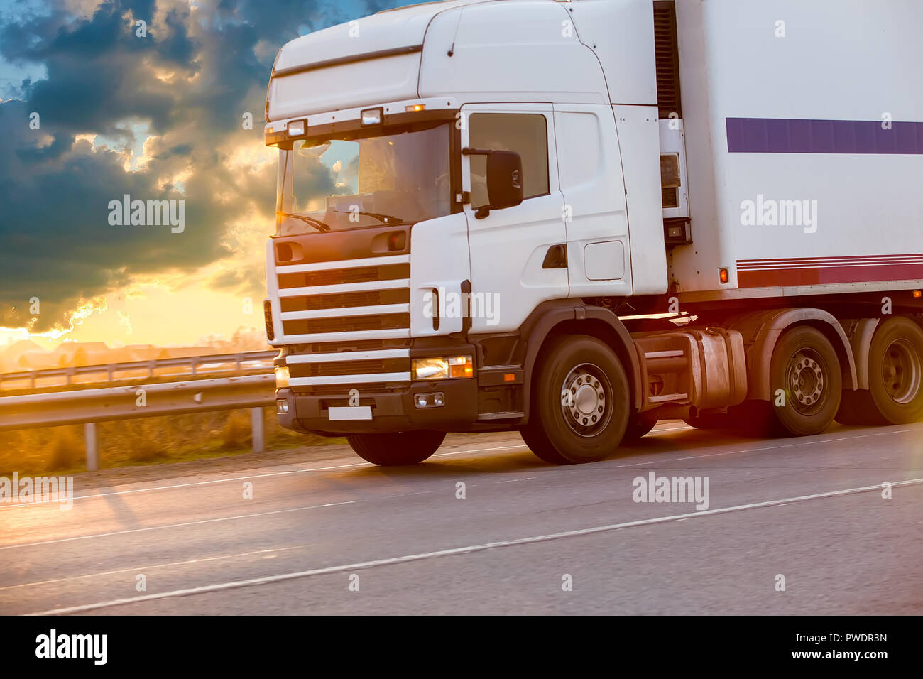 truck goes on highway in evening on sunset Stock Photo - Alamy